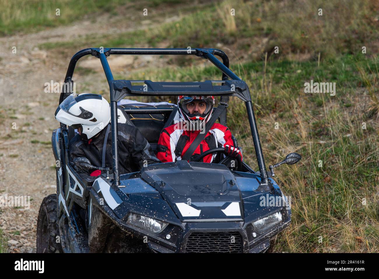 A man driving a quad ATV motorcycle through beautiful meadow landscapes ...