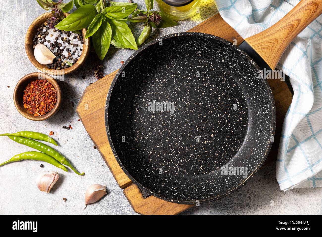 Empty skillet, vegetables, spices and herbs on gray stone background ...
