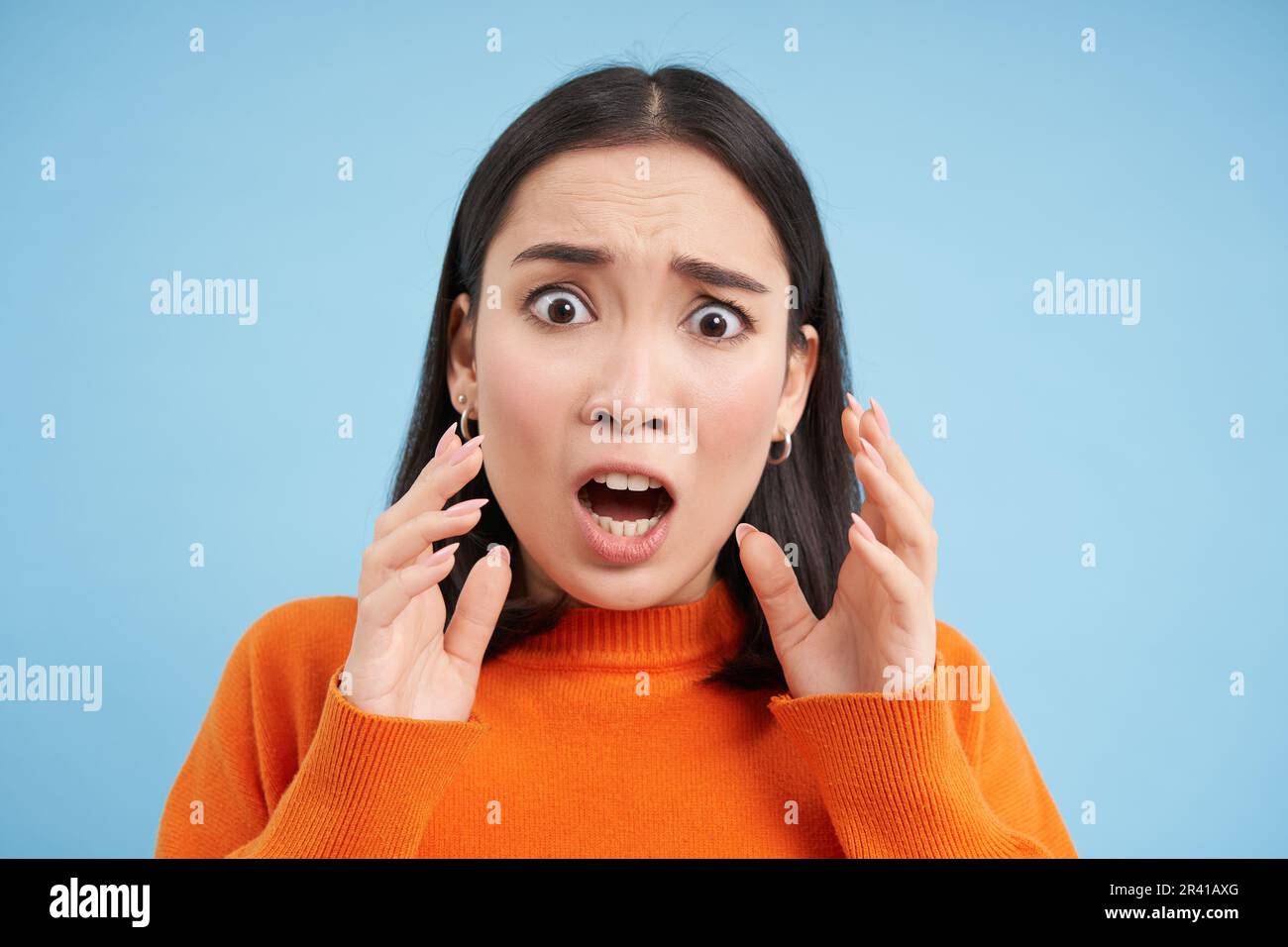 Close up of shocked asian woman in panic, anxious, looks terrified ...