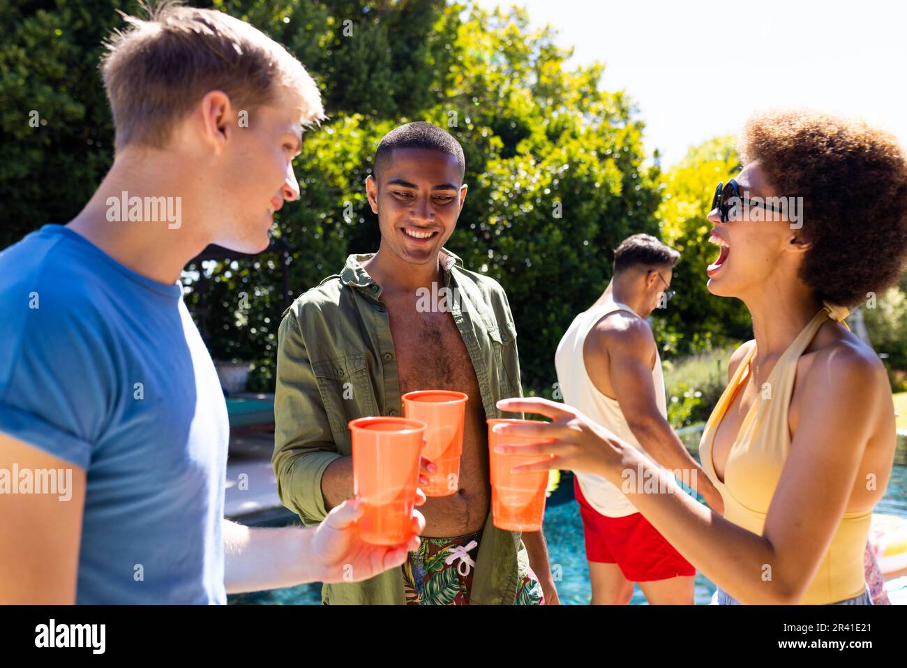 Happy diverse group of friends having pool party, making a toast in ...