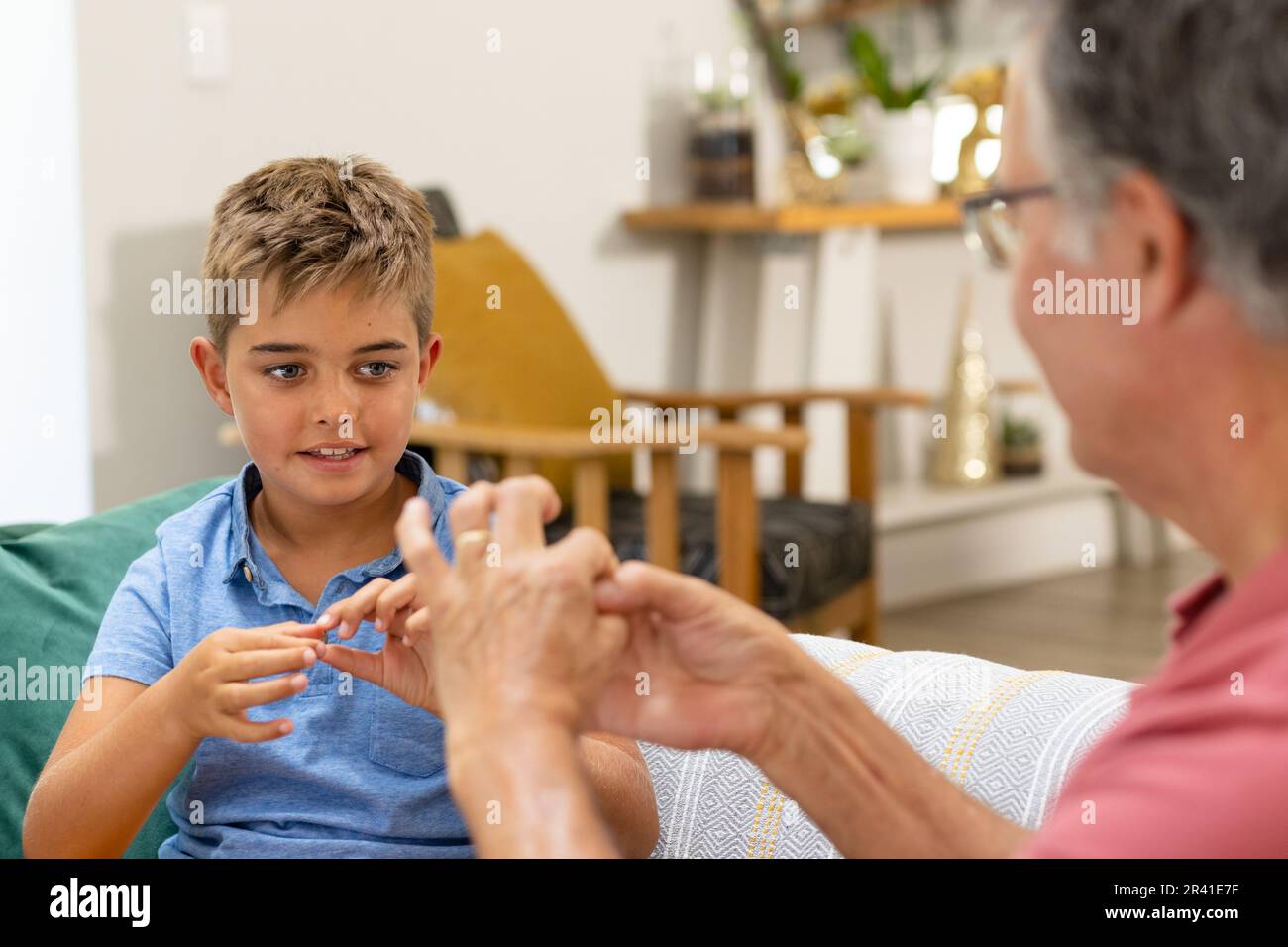 Caucasian cute boy talking with grandfather in sign language while ...