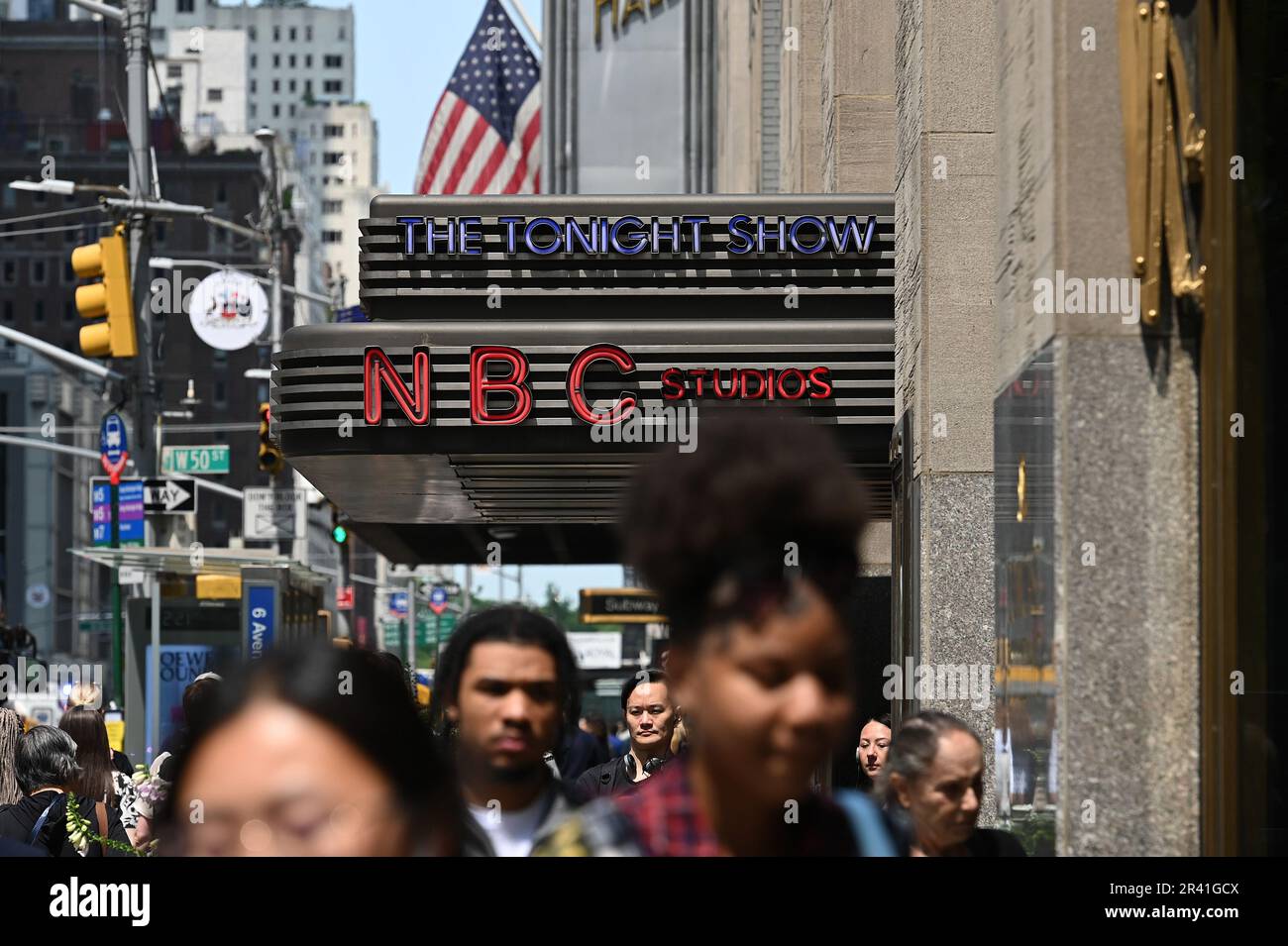New York, USA. 24th May, 2023. People walk under neon signage for NBC's ...