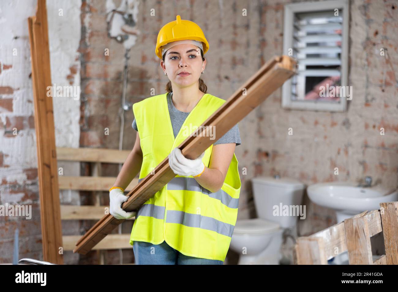 Female carrying wooden panel on construction site Stock Photo - Alamy