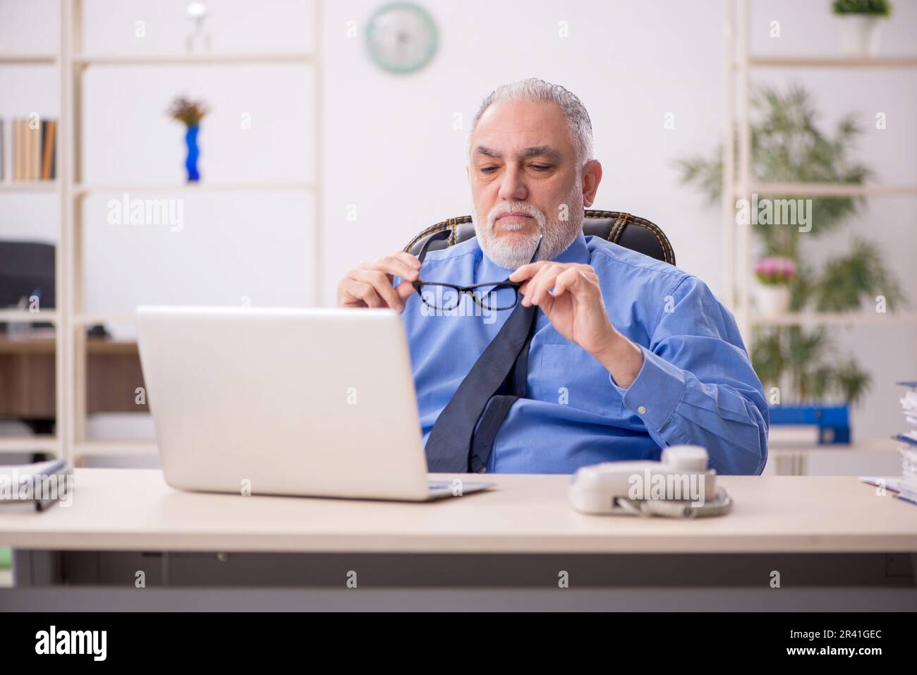 Old male employee working in the office Stock Photo - Alamy