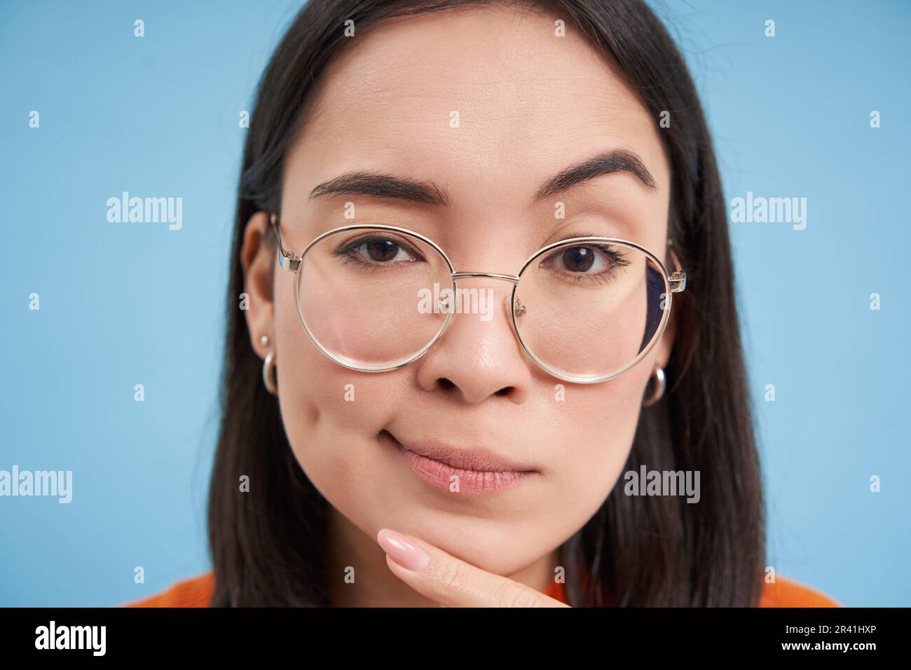 Close up portrait of asian woman looks intrigued, wears glasses ...