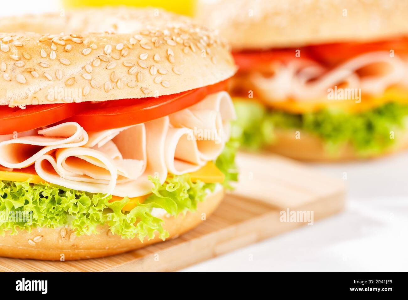 Bagel roll sandwich for breakfast topped with chicken ham close up in ...