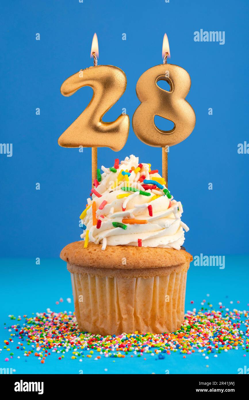 Birthday cake with candle number 28 - Blue background Stock Photo - Alamy