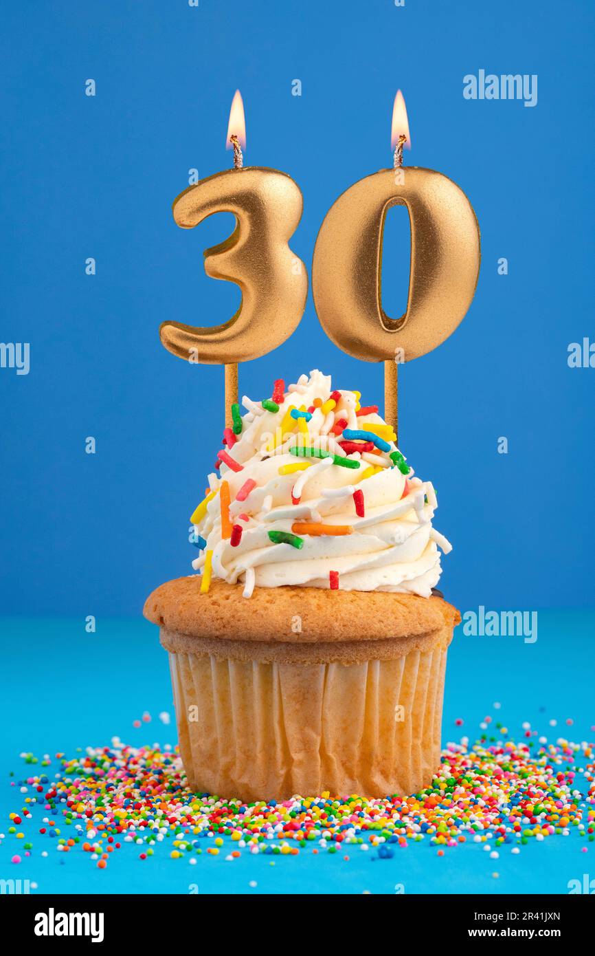 Birthday cake with candle number 30 - Blue background Stock Photo - Alamy
