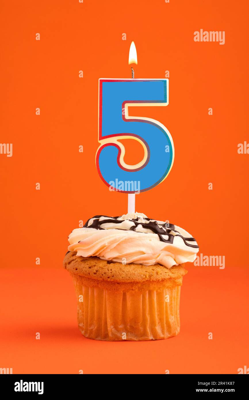 Blue number 5 candle - Birthday cake on orange background Stock Photo ...