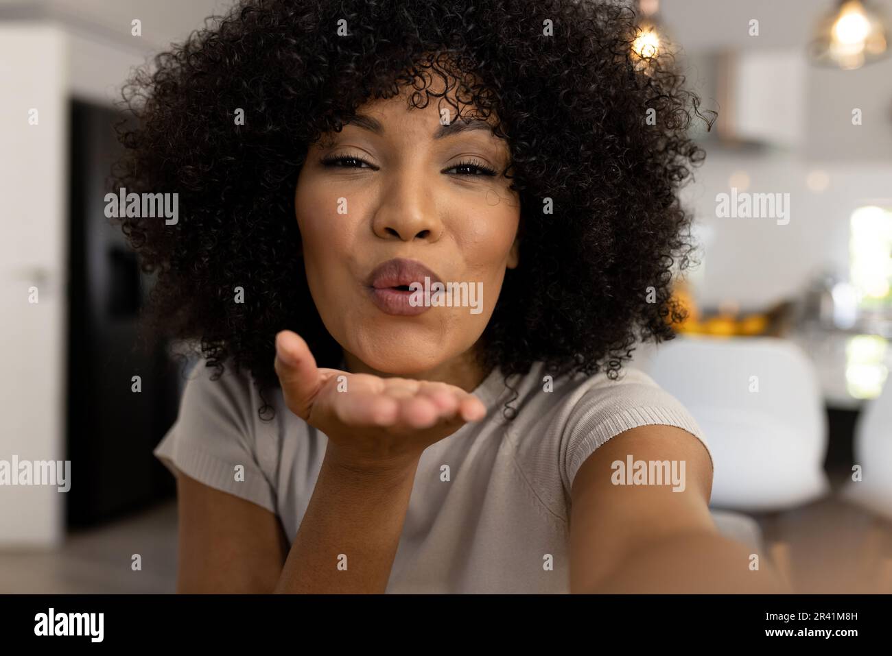 Portrait Of Happy Biracial Woman With Afro At Home Making Video Call