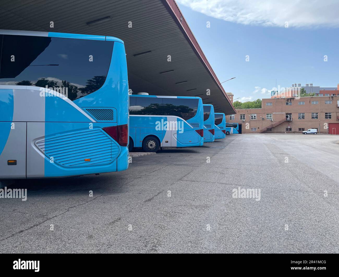 parking garage of a bus station with a group of blue buses parked in a ...
