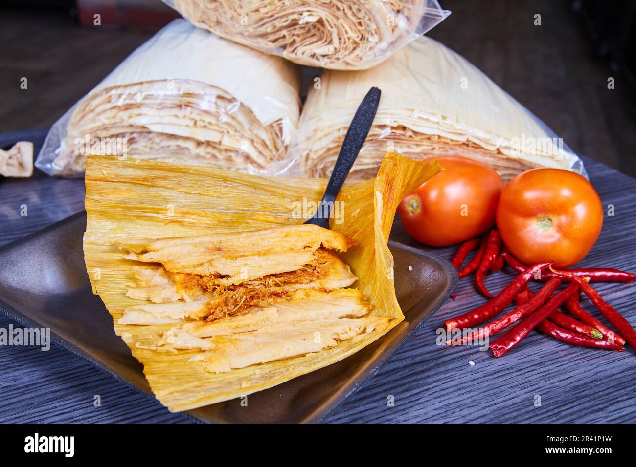 Open tamale and fork in pork filling red peppers, Roma tomatoes and ...