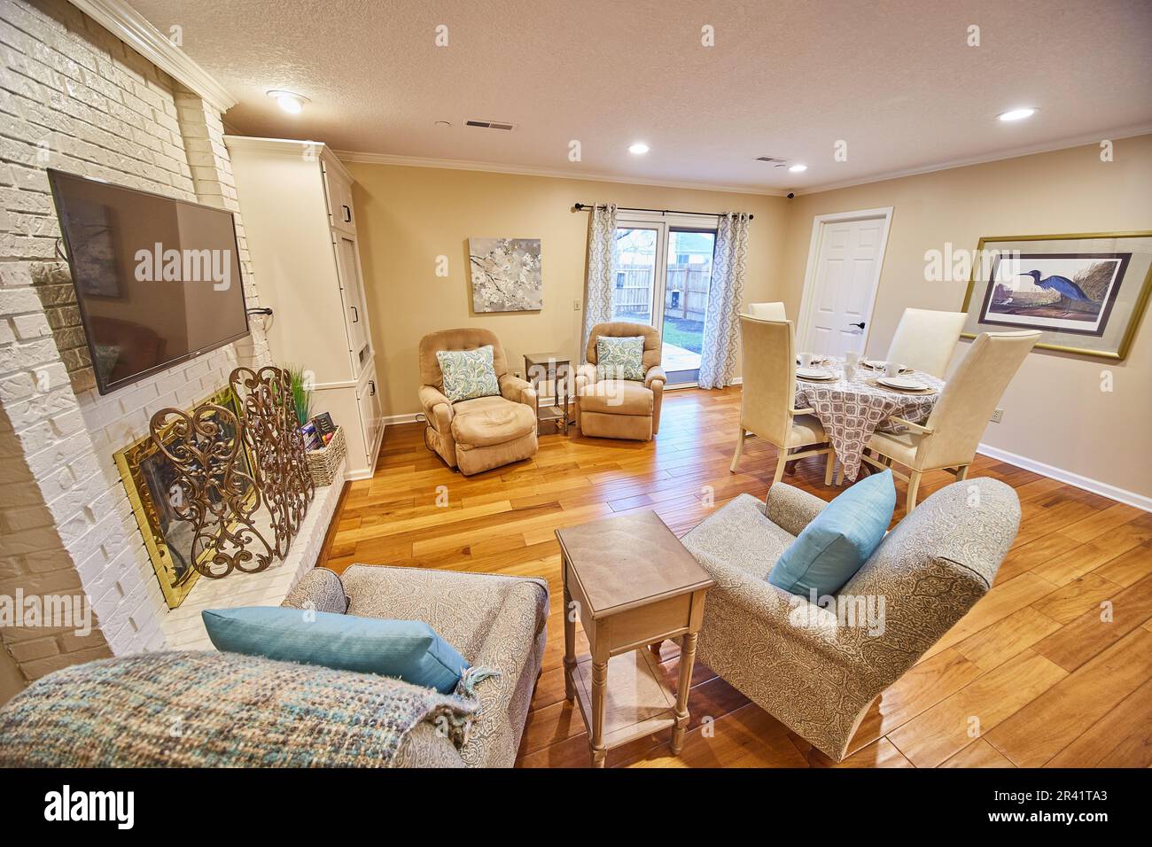 Beige living room with hard wood floor, couches, dining room table set ...