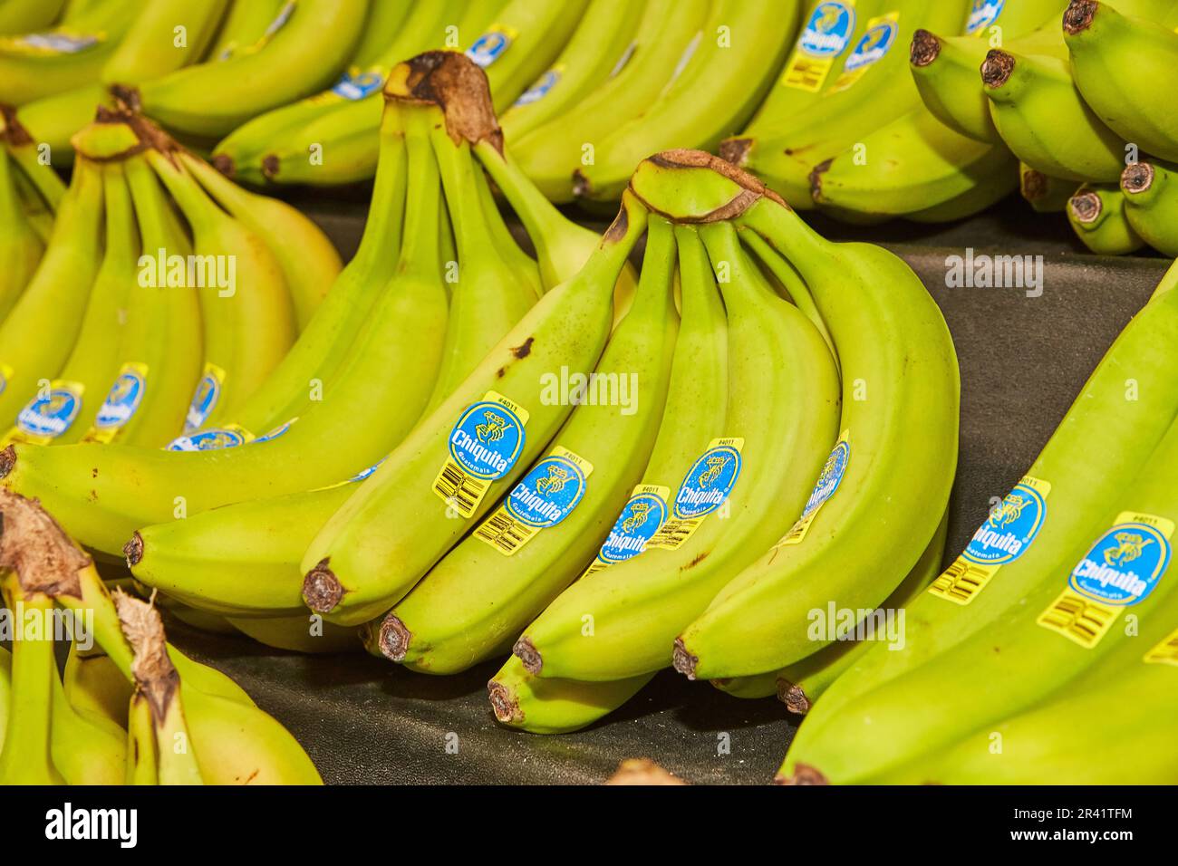 Bunches and bundles of yellow bananas on non-descript black shelf Stock ...
