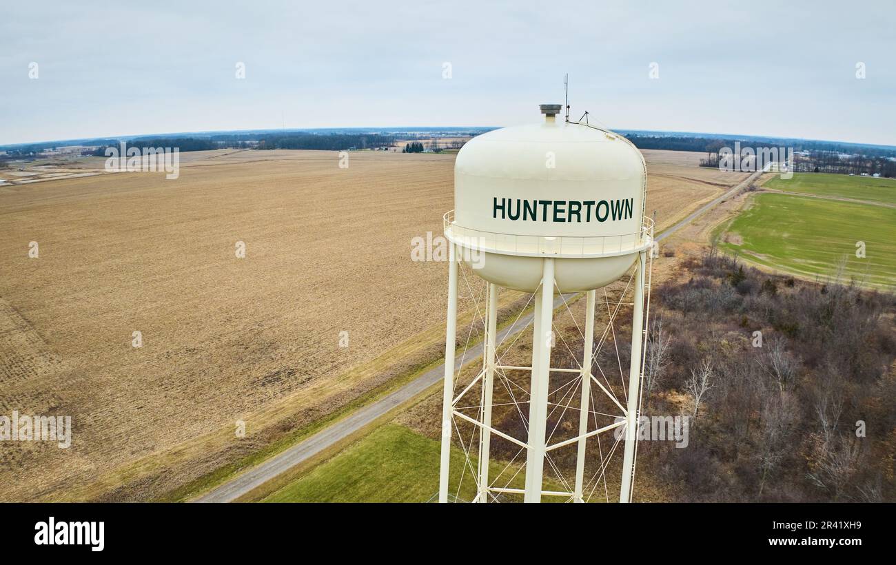 Drone aerial of empty field, partial forest in winter and green grass ...