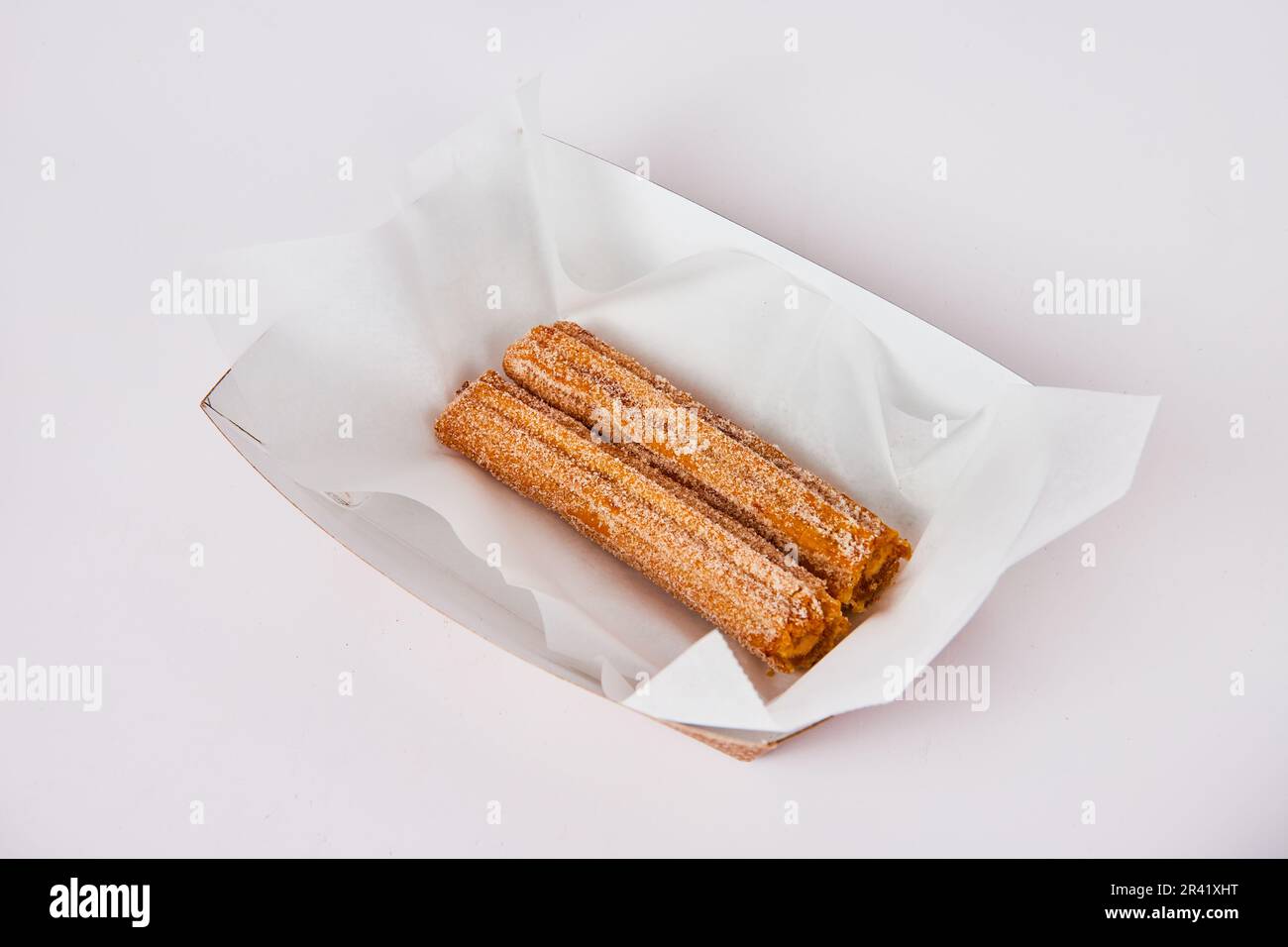 Two Mexican sweet churro pastries in whit tray on white background ...