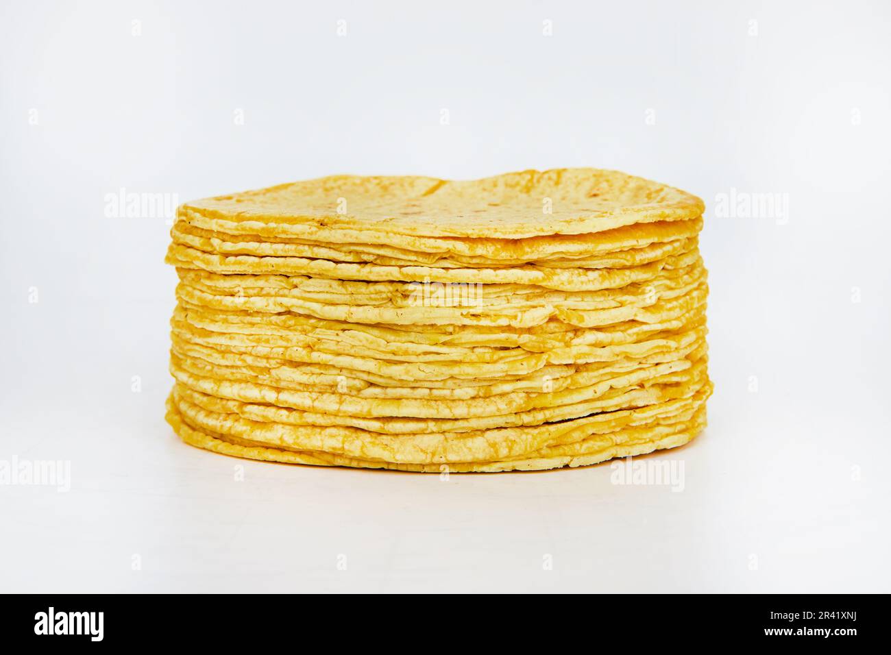 Side view of a stack of 20 corn tortillas pre-grilled on white ...