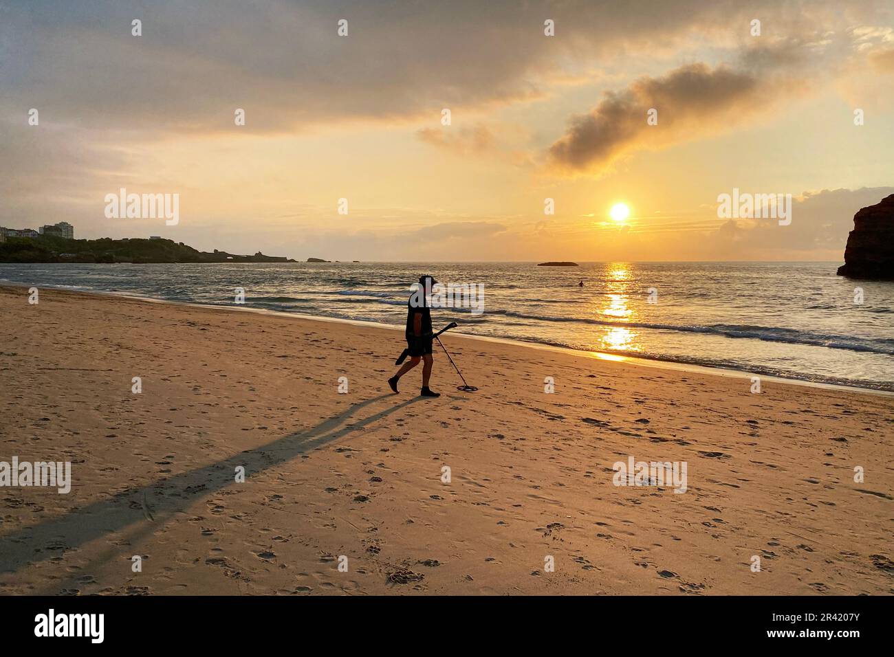 Metal Detectorist Searching on a Beach at Sunset Stock Photo - Alamy