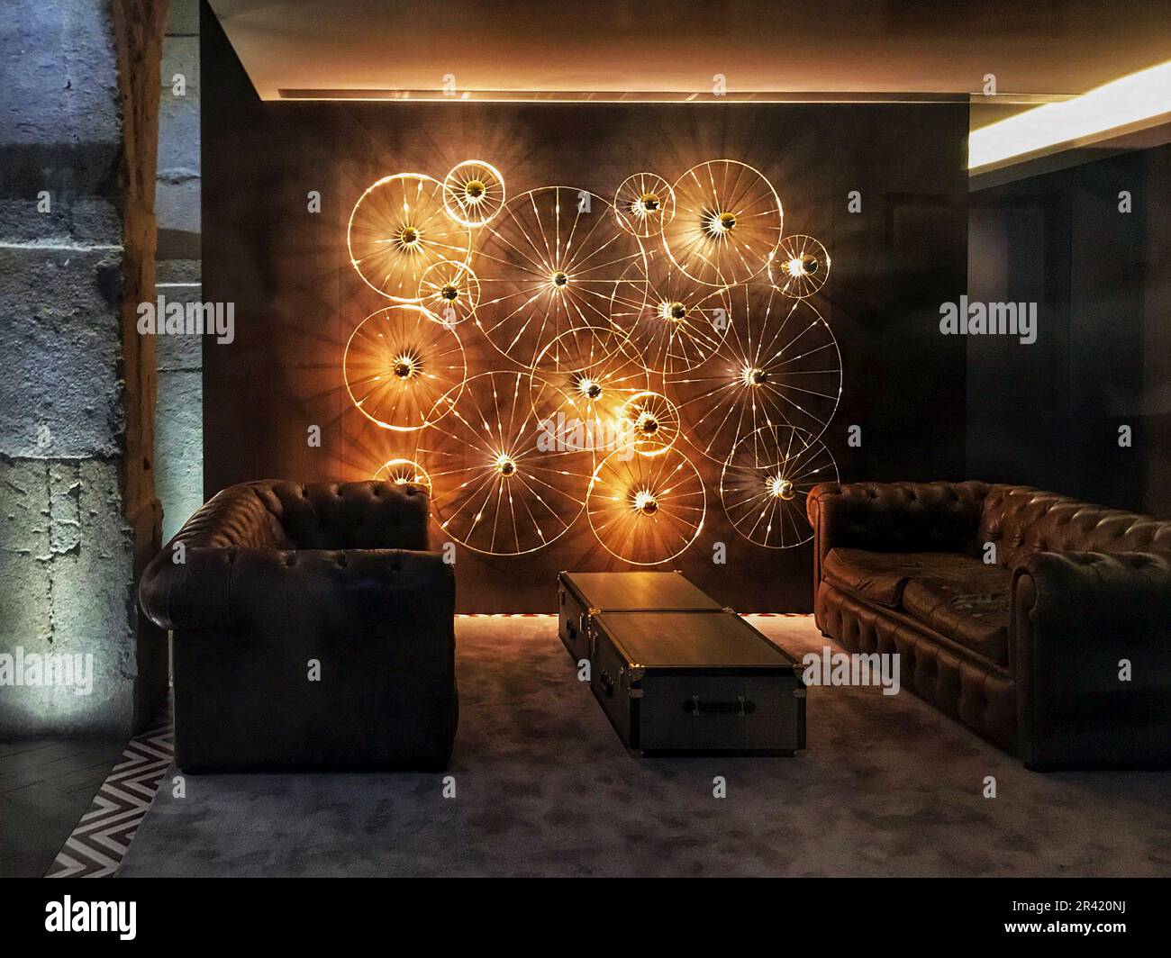 Cozy Lounge Interior with Artistic Wheel Lighting Stock Photo - Alamy