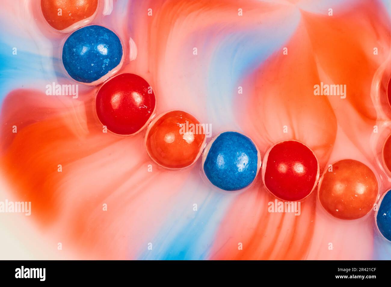 Tie dye effect from orange and red and blue skittles in water Stock ...