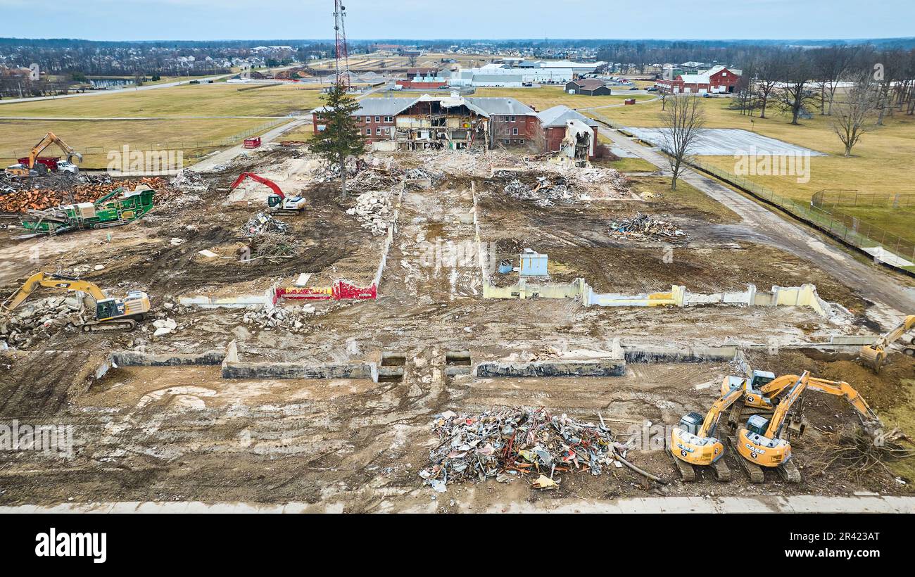 Aerial of construction vehicles near a destroyed building with debris ...