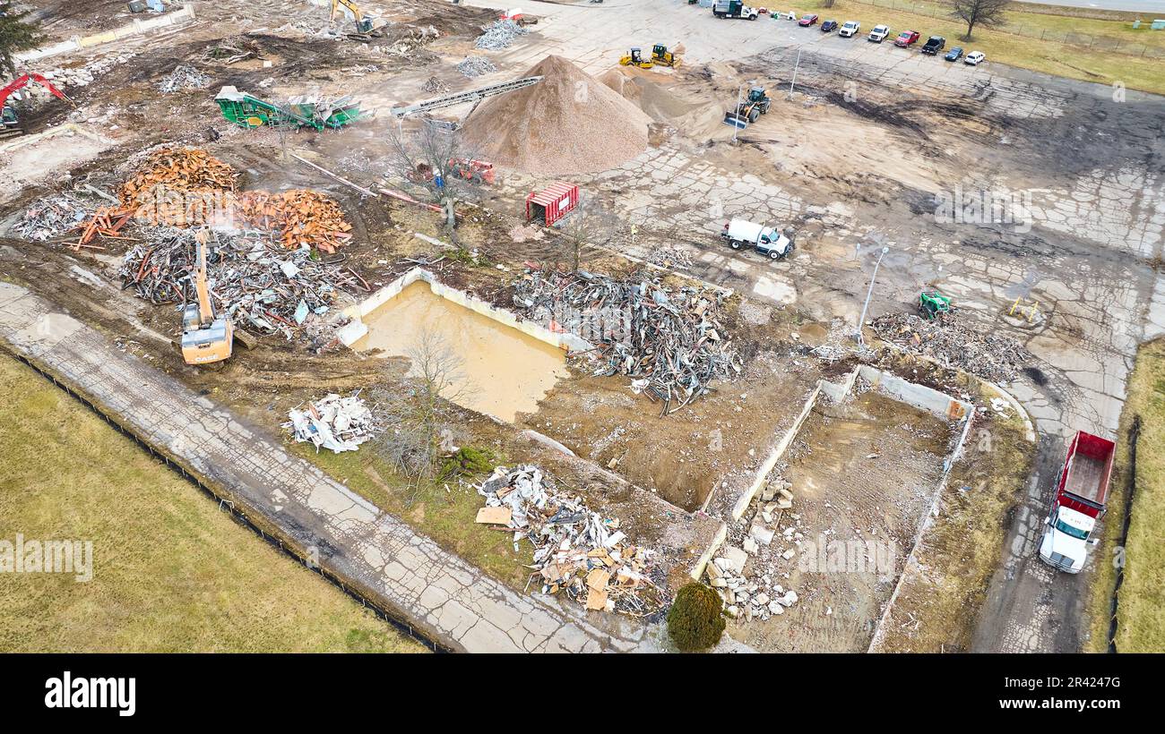 Remnant of a pool at construction zone with piles of scrap and debris ...