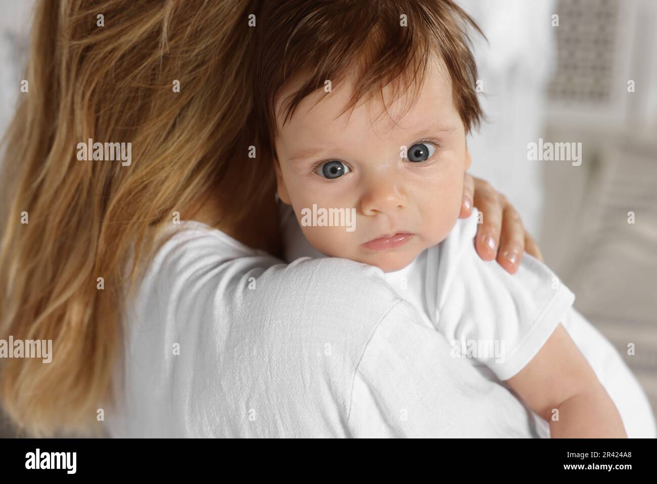 Mother hugging her cute little baby indoors, closeup Stock Photo - Alamy