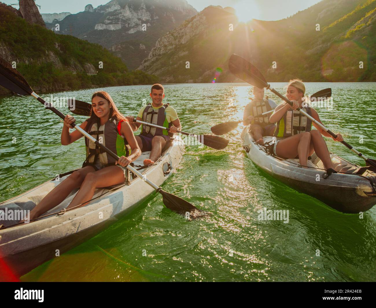 A group of friends enjoying fun and kayaking exploring the calm river ...