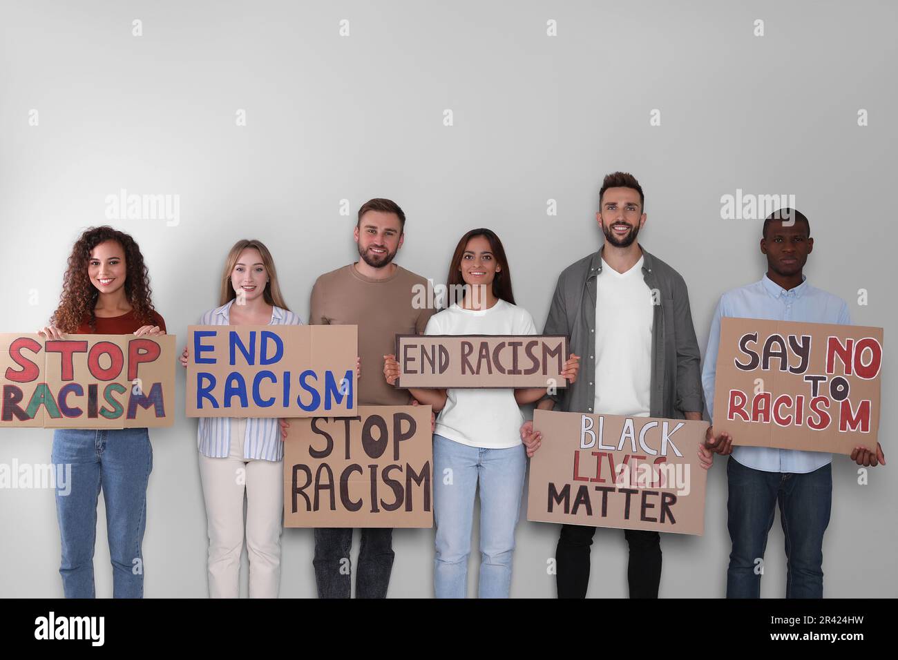 Protesters demonstrating different anti racism slogans on light ...