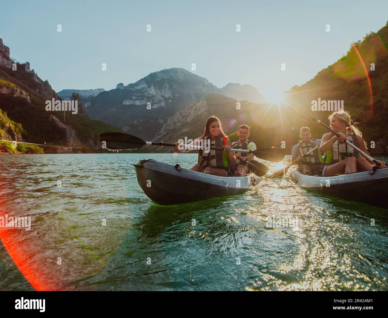 A group of friends enjoying fun and kayaking exploring the calm river ...
