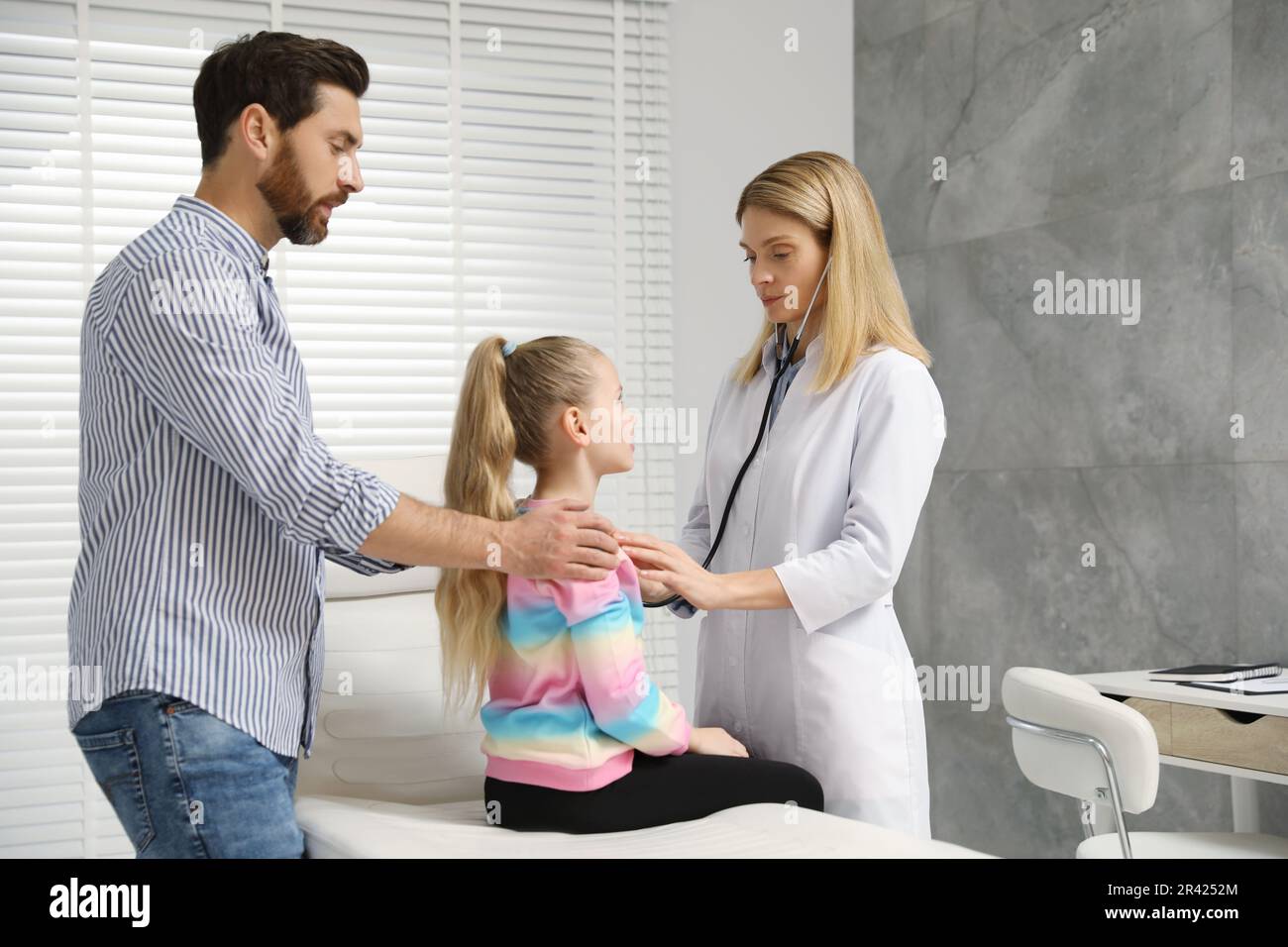 Father and daughter having appointment with doctor. Pediatrician ...