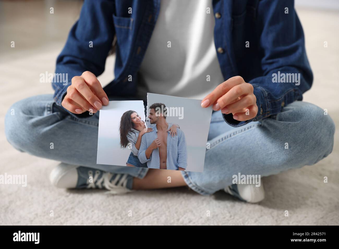 Woman ripping photo on floor, closeup. Divorce concept Stock Photo - Alamy