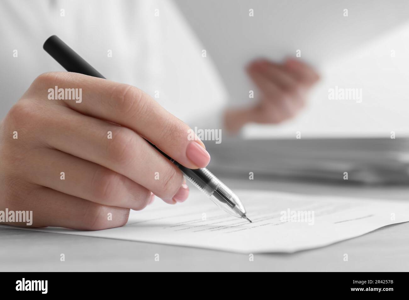 Woman signing documents at wooden table in office, closeup. Space for ...