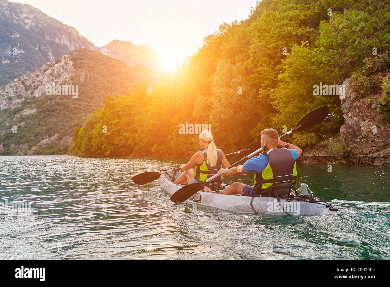 A group of friends enjoying fun and kayaking exploring the calm river ...