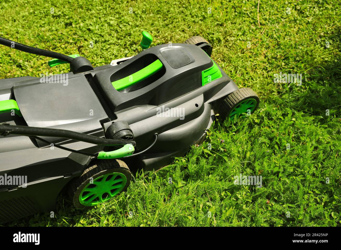 Cutting green grass with lawn mower in garden Stock Photo - Alamy