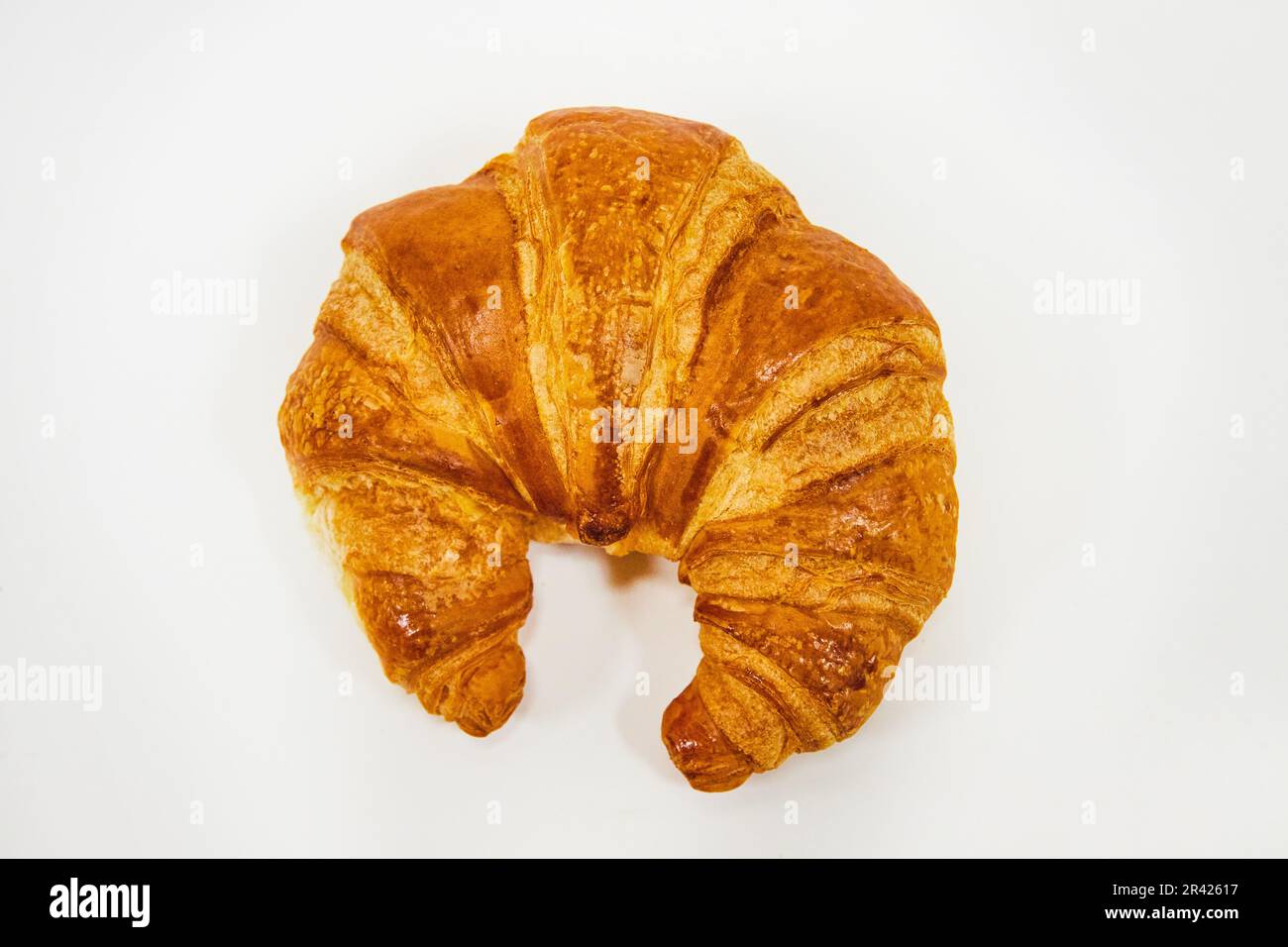 Top down view of fresh baked crescent shaped croissant on white ...