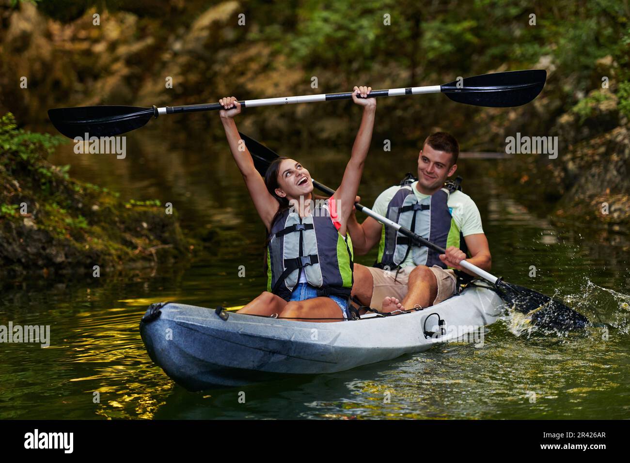 A young couple enjoying an idyllic kayak ride in the middle of a ...