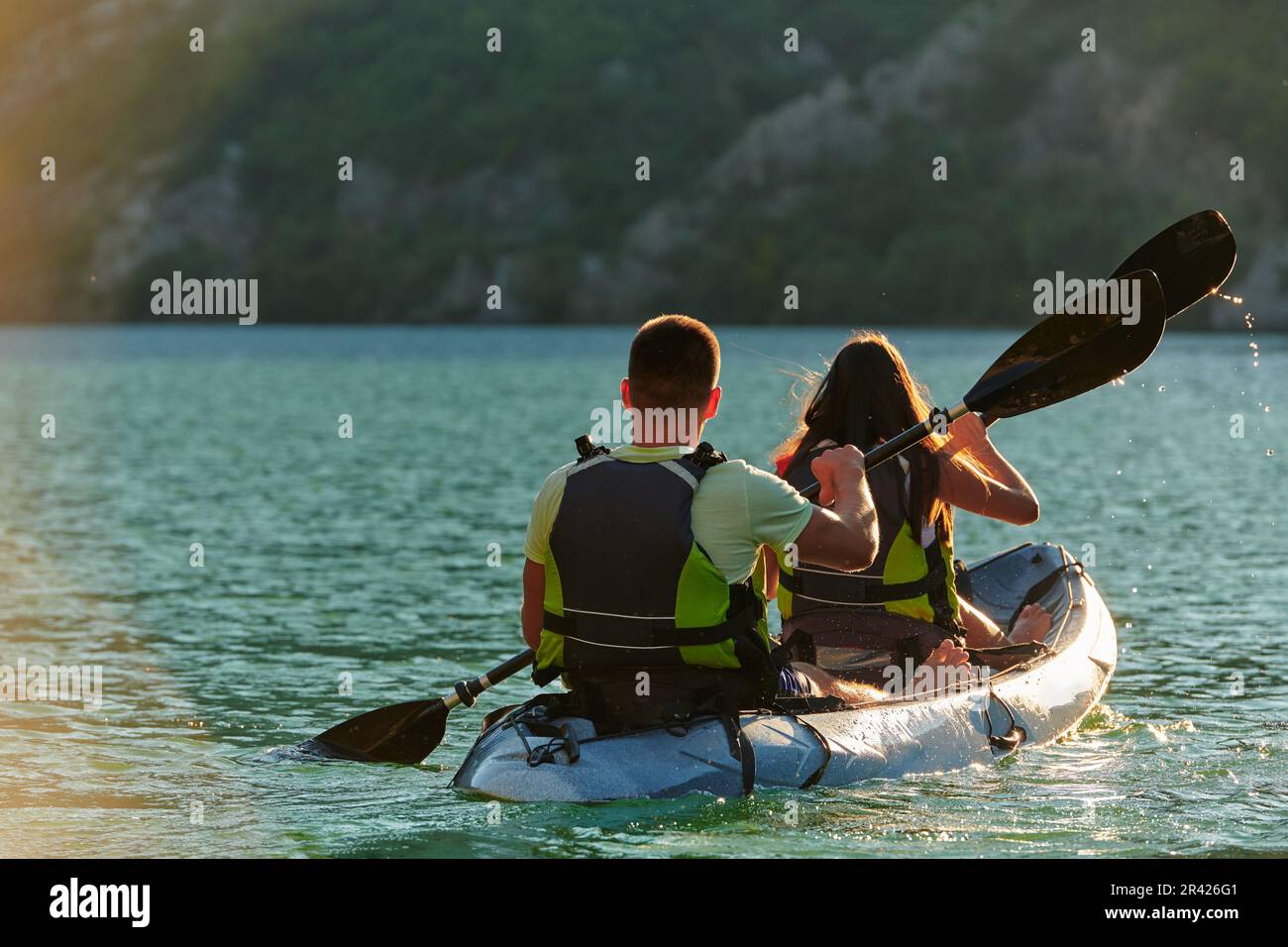 A young couple enjoying an idyllic kayak ride in the middle of a ...