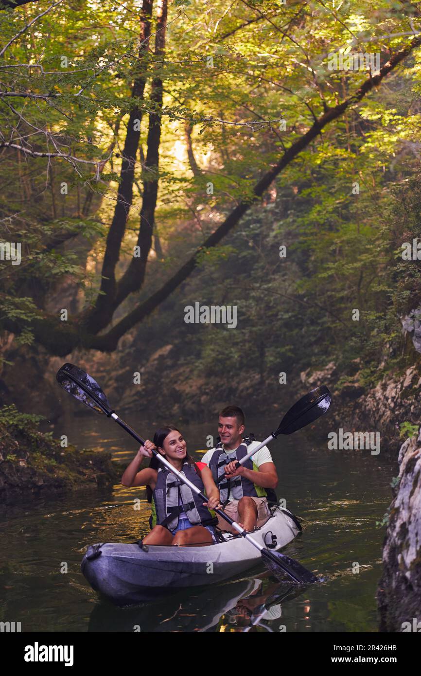 A young couple enjoying an idyllic kayak ride in the middle of a ...