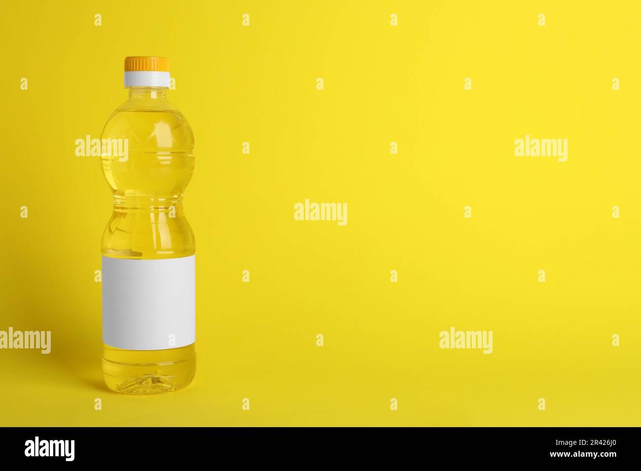 Bottle of cooking oil on yellow background. Space for text Stock Photo ...