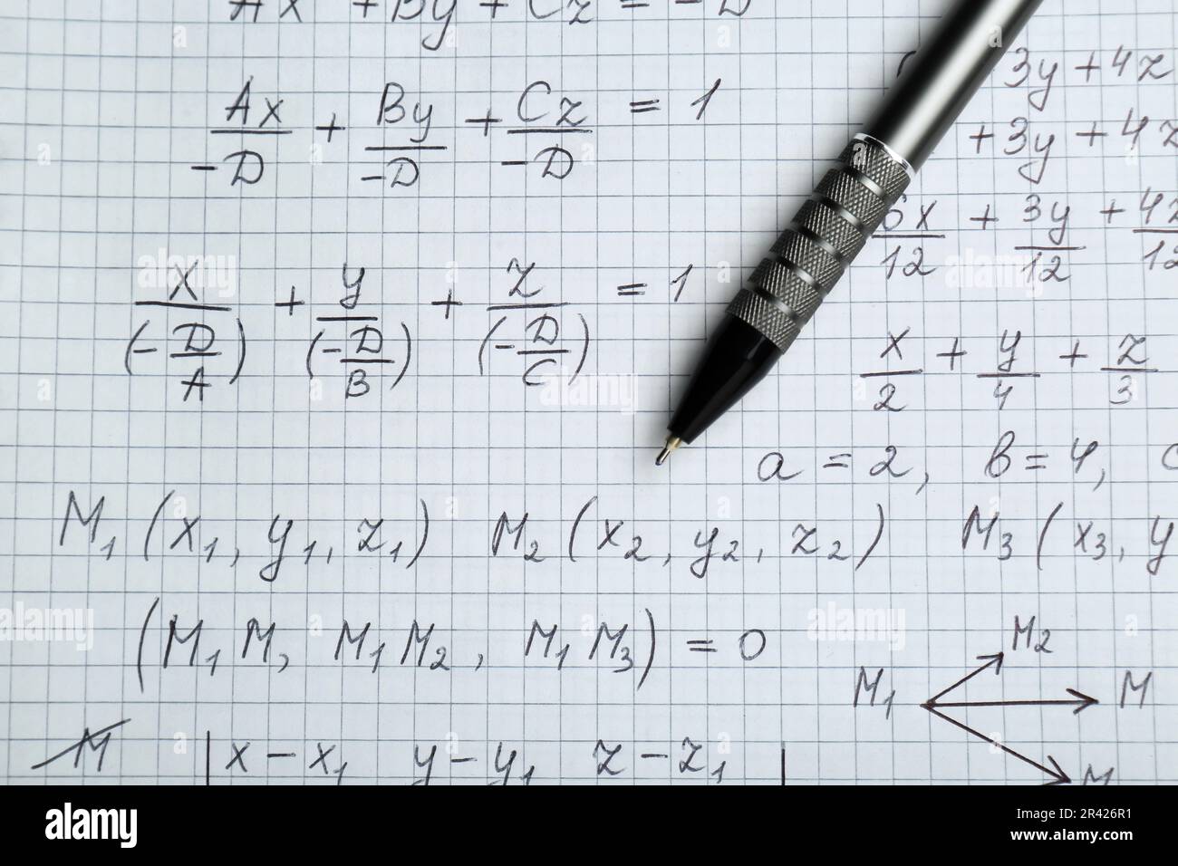 Sheet of paper with different mathematical formulas and pen, top view ...