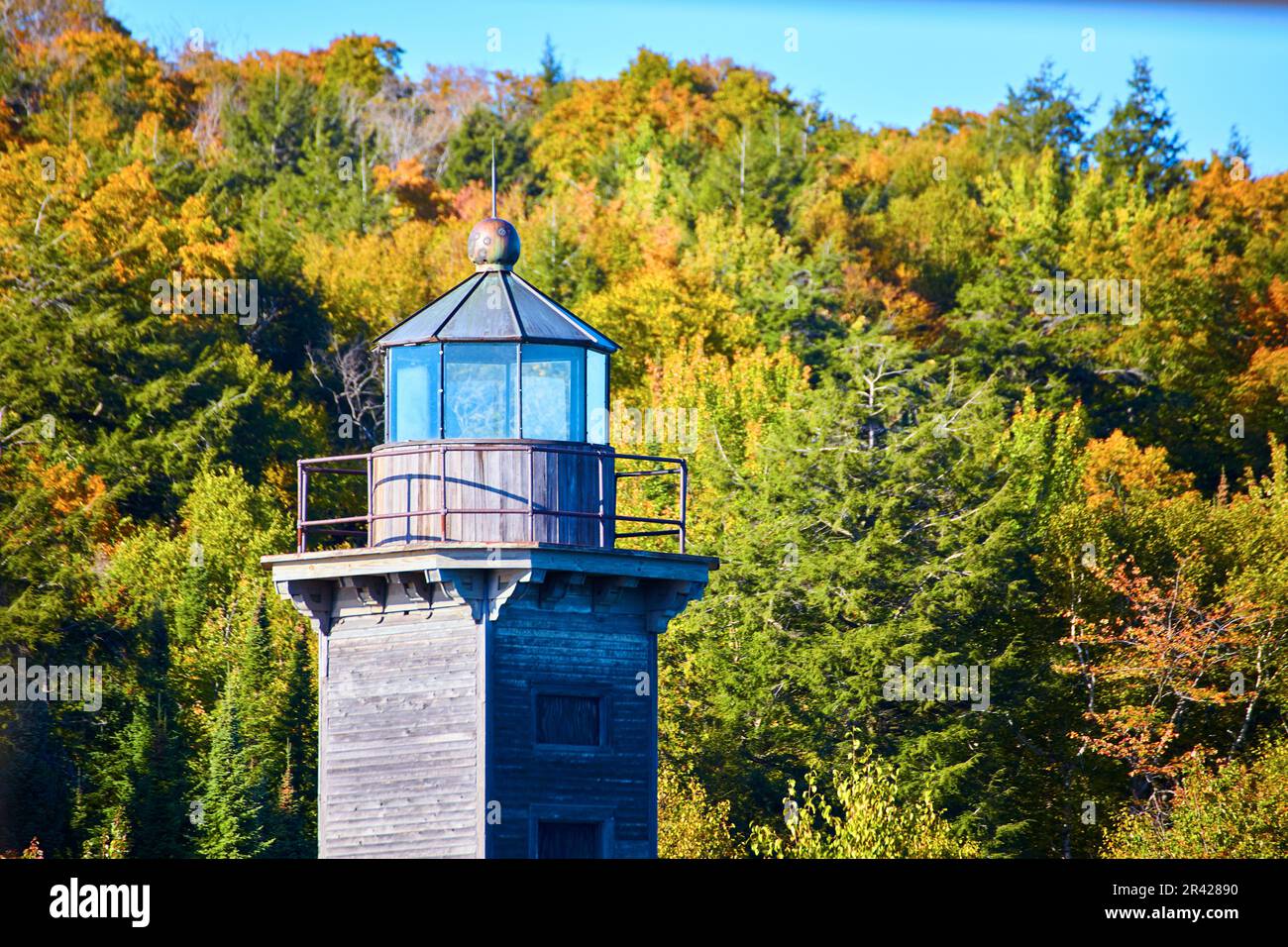 Watch tower lighthouse with forest wall of green summer trees with some ...