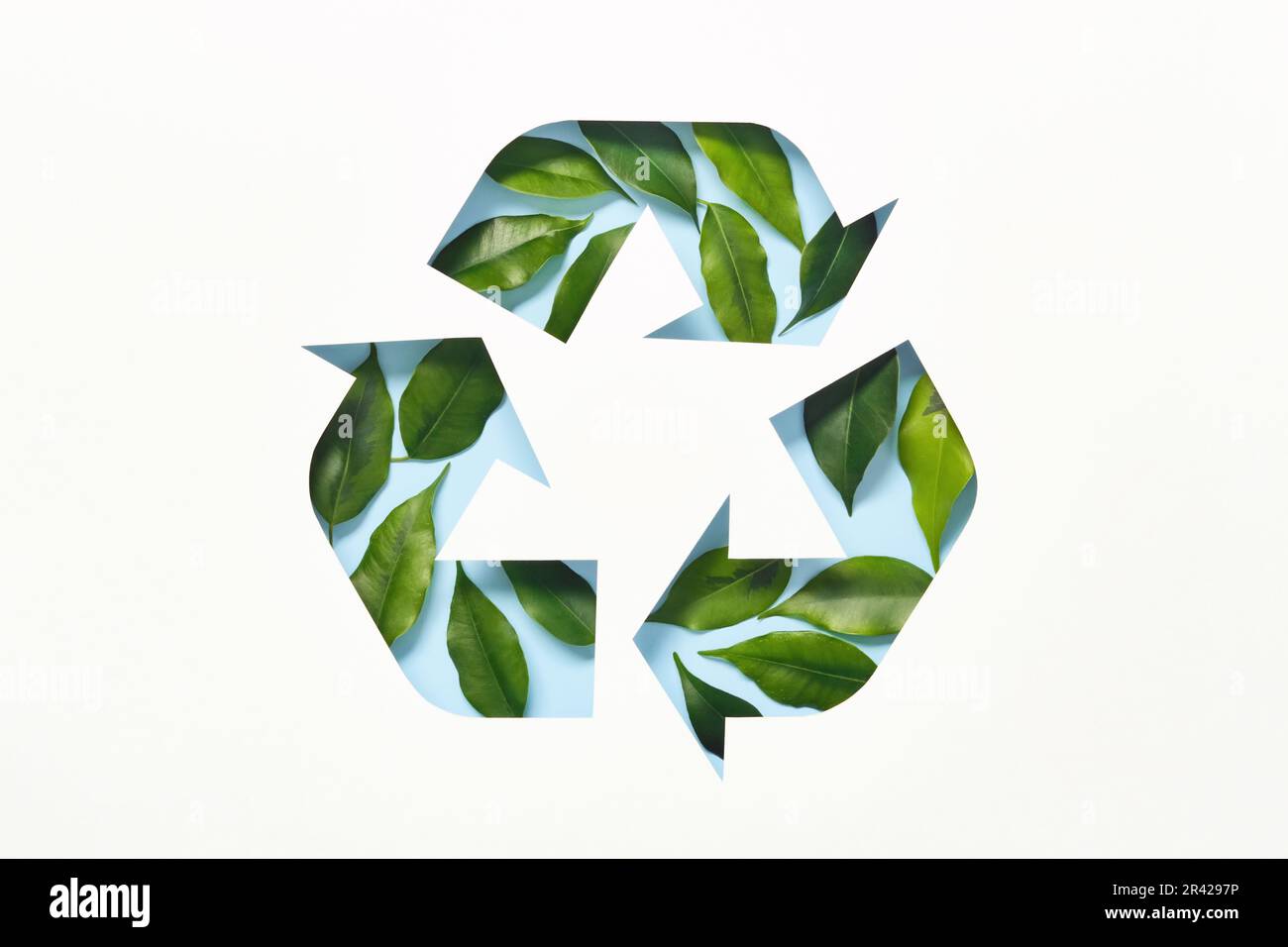 Recycle symbol made of cut paper and green leaves on blue background. Reuse, reduce, recycle ...