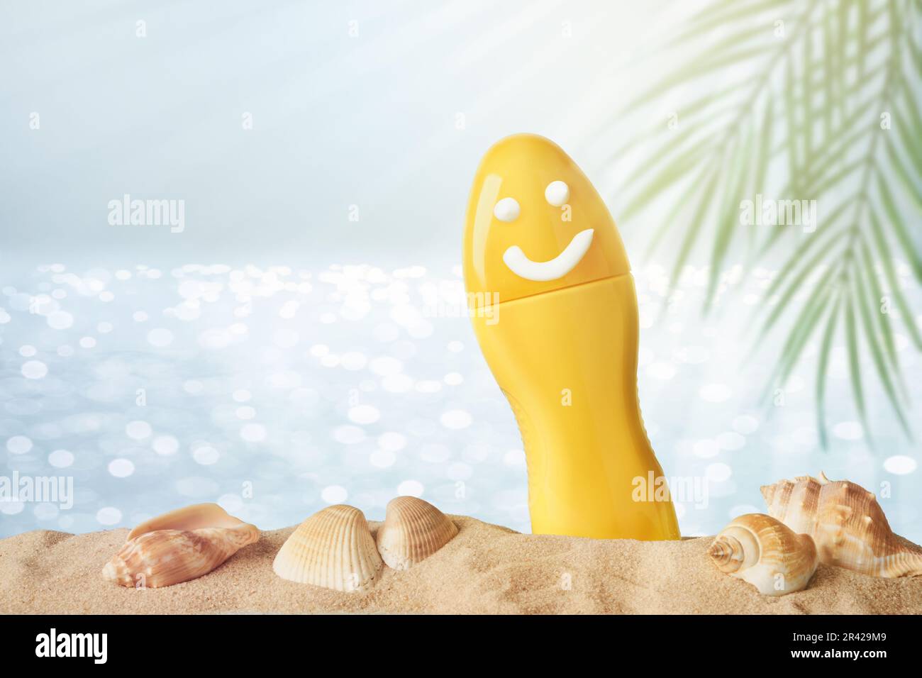 Yellow tube with happy sunscreen face on blurred sea background with ...