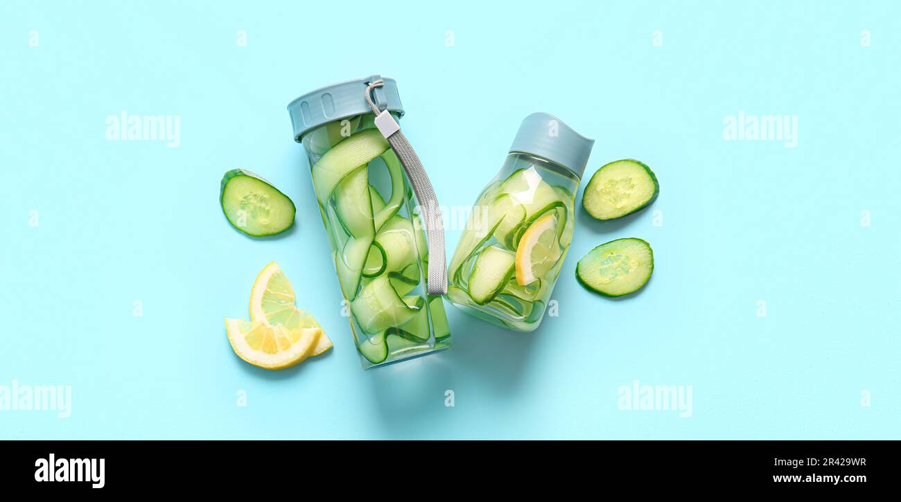 Bottles of cucumber infused water on light blue background Stock Photo ...