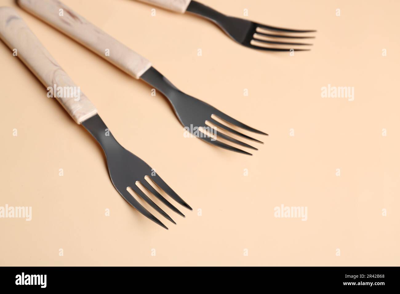 Stylish forks on beige background Stock Photo - Alamy