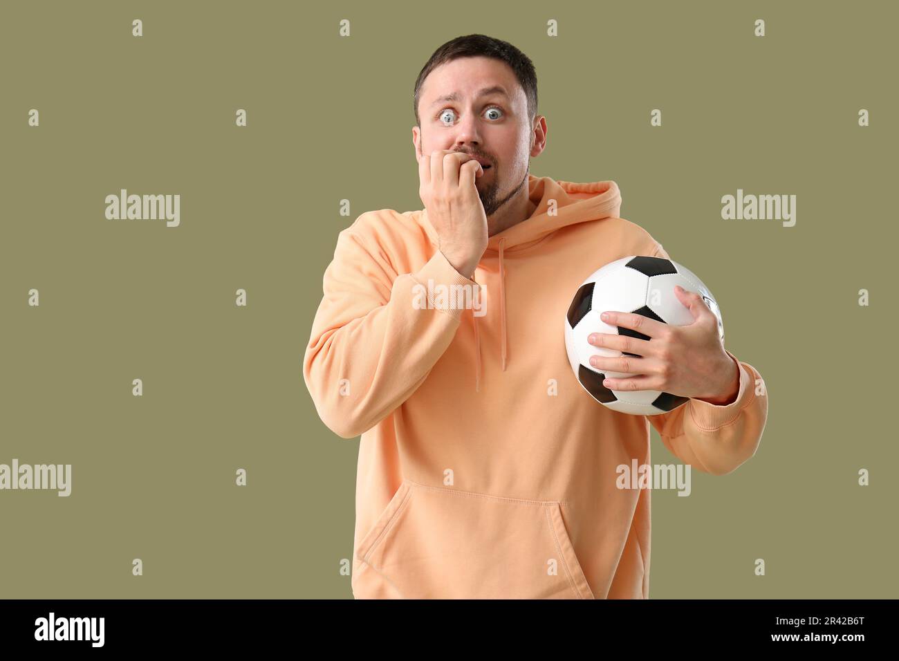Scared man with soccer ball on color background Stock Photo - Alamy