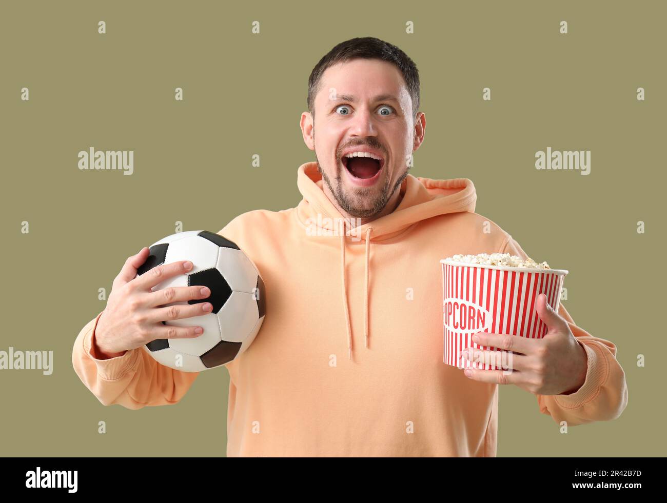 Screaming soccer fan with ball and popcorn on color background Stock ...