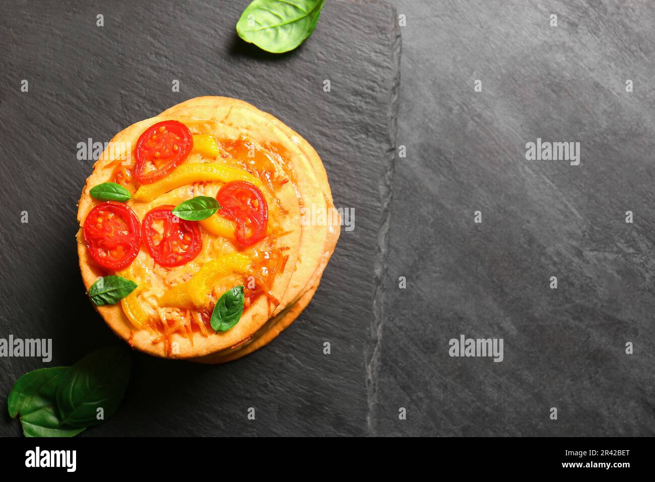Board with tasty mini pizzas on black background Stock Photo - Alamy
