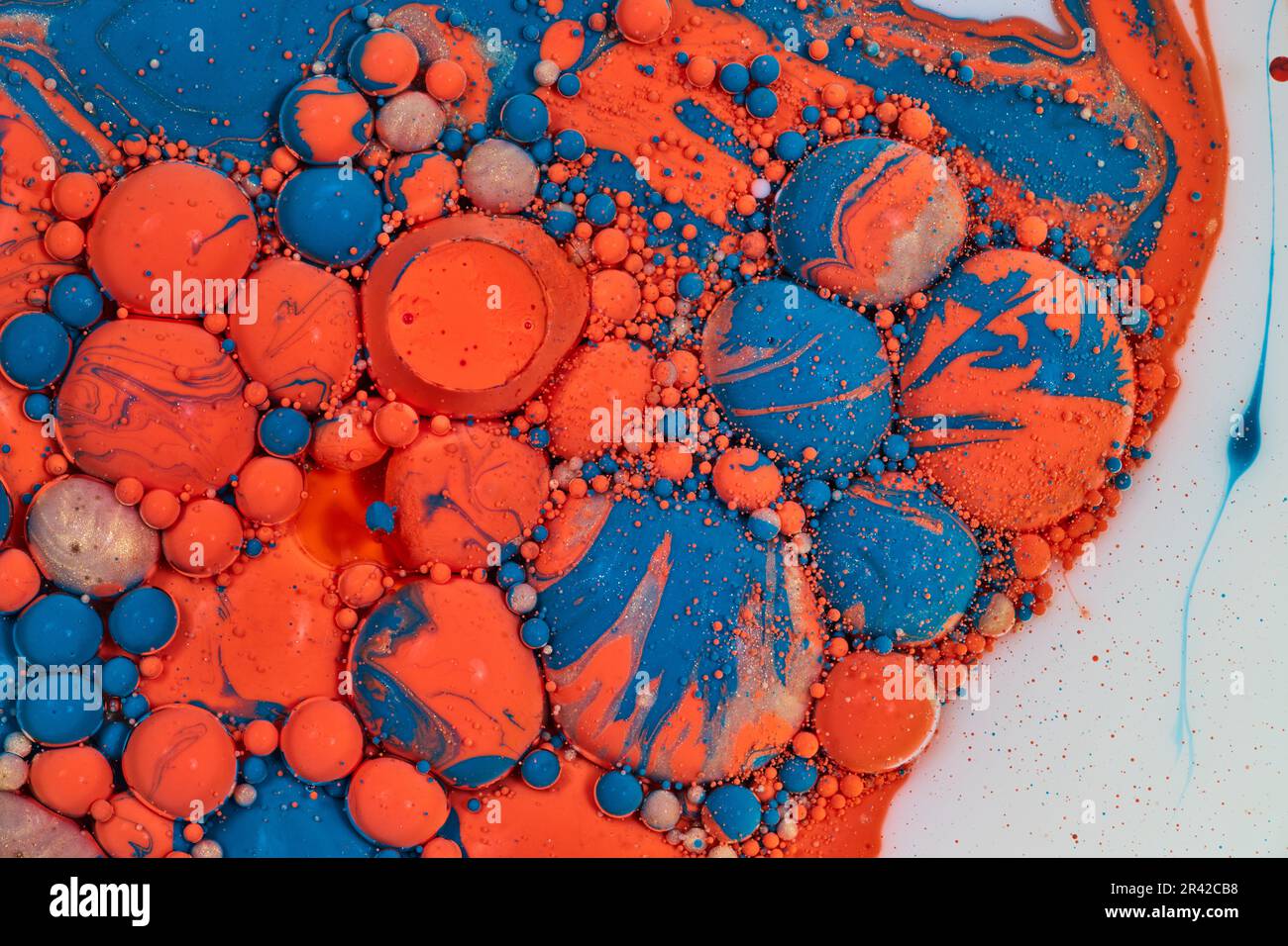 Bubbles popping in acrylic pouring of oil and blue gold orange and ...